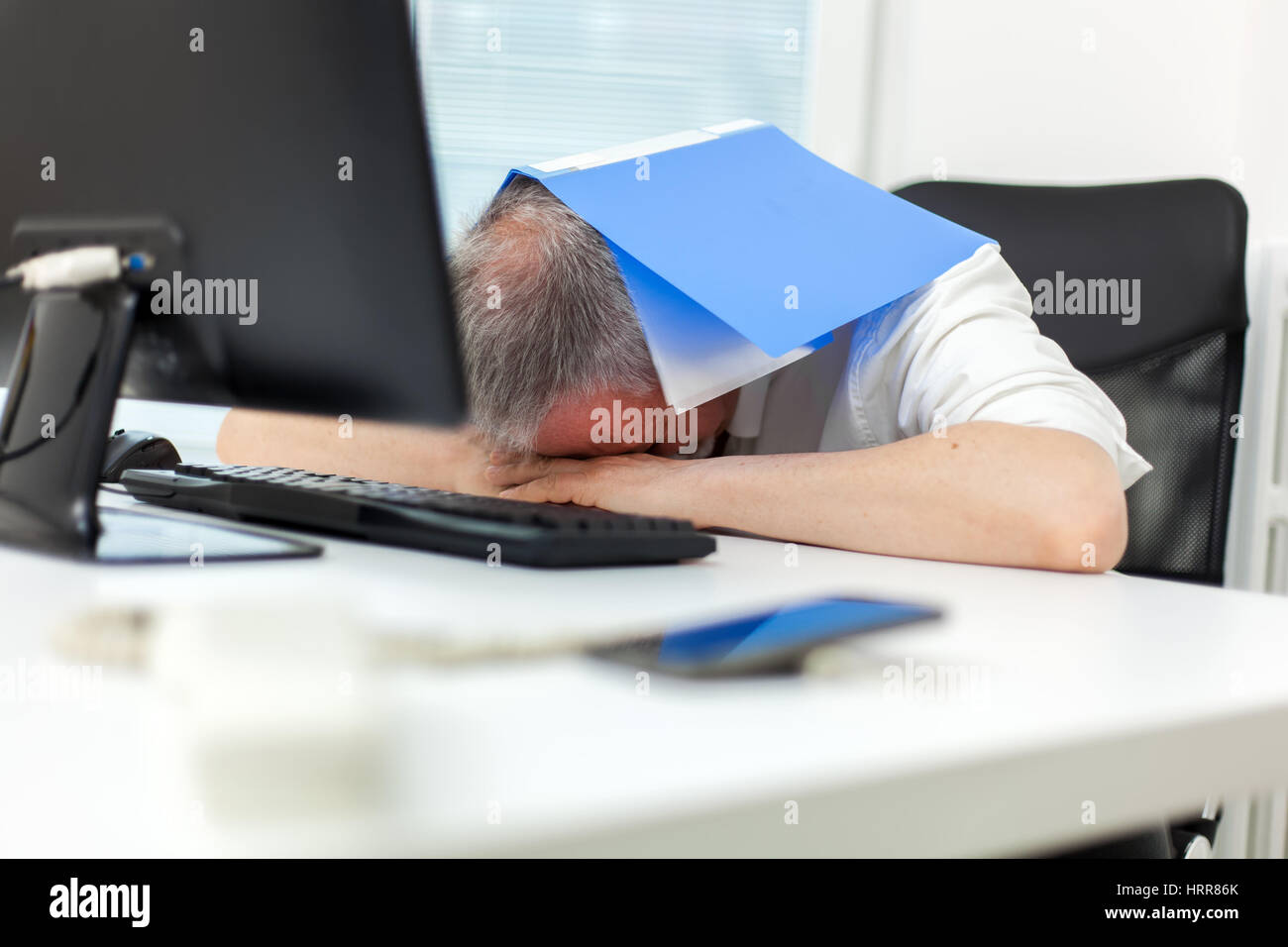 Bored businessman full of work Stock Photo - Alamy