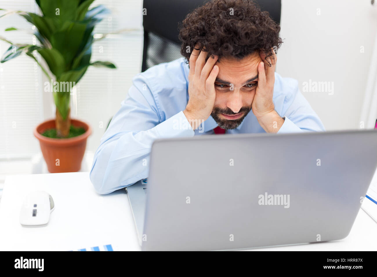 Angry businessman looking at his computer Stock Photo - Alamy