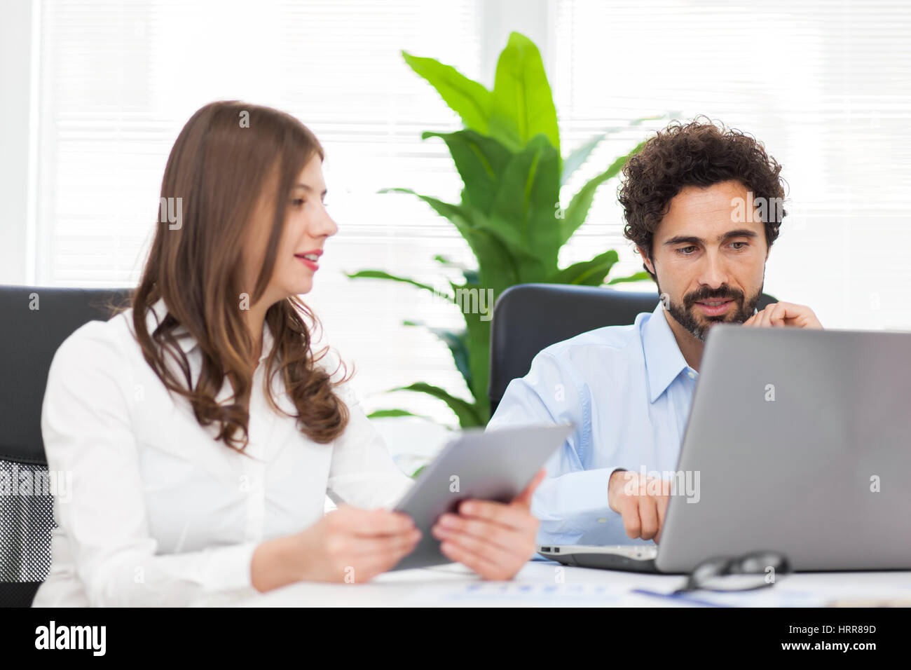 Two young business partners discussing plans or ideas at meeting Stock ...
