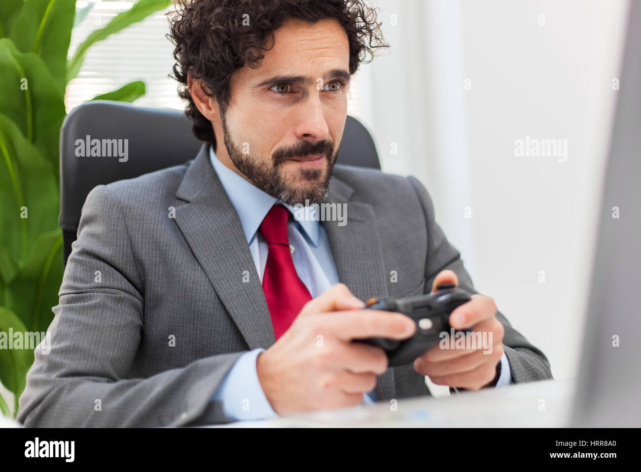 Businessman playing videogames in his office Stock Photo - Alamy