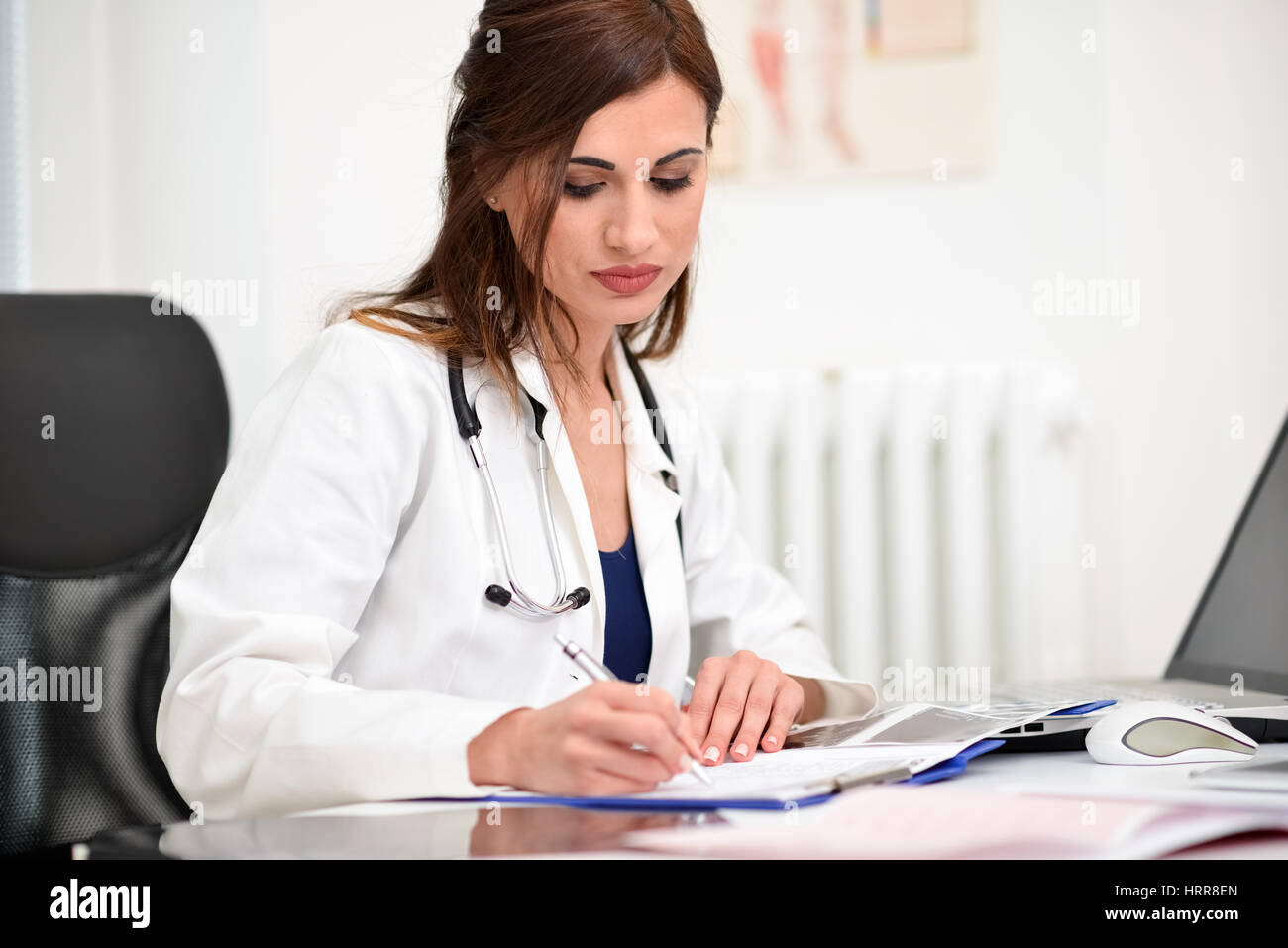 Doctor doing paperwork in her office Stock Photo - Alamy