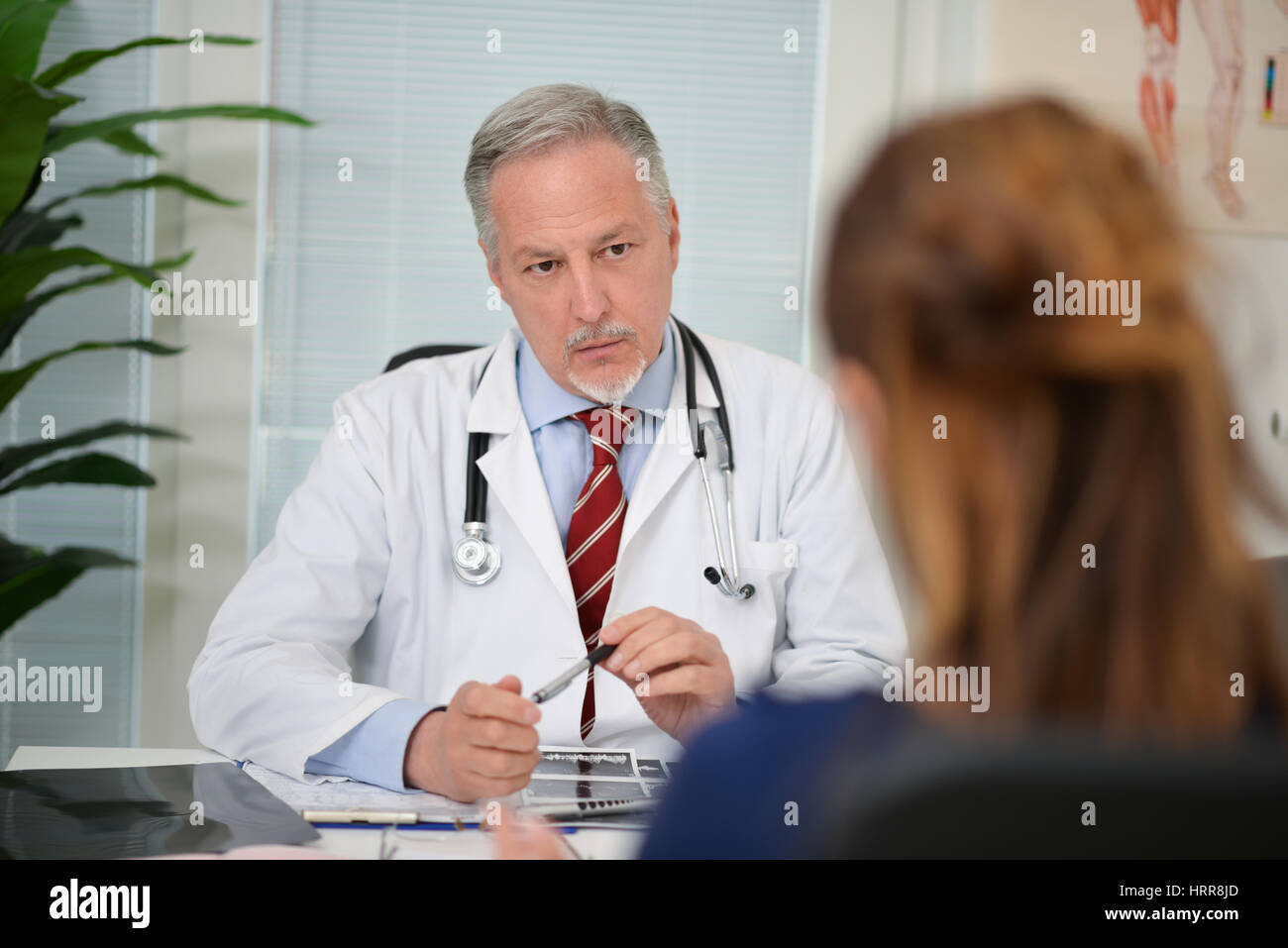 Doctor listening to a patient in his office Stock Photo - Alamy