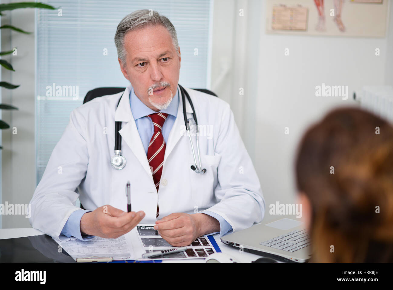 Doctor listening to a patient in his office Stock Photo - Alamy