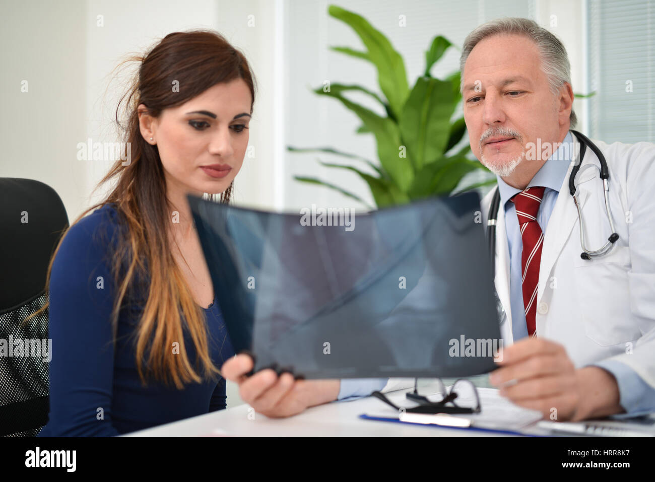 Doctor speaking to his patient while showing an x-ray Stock Photo - Alamy