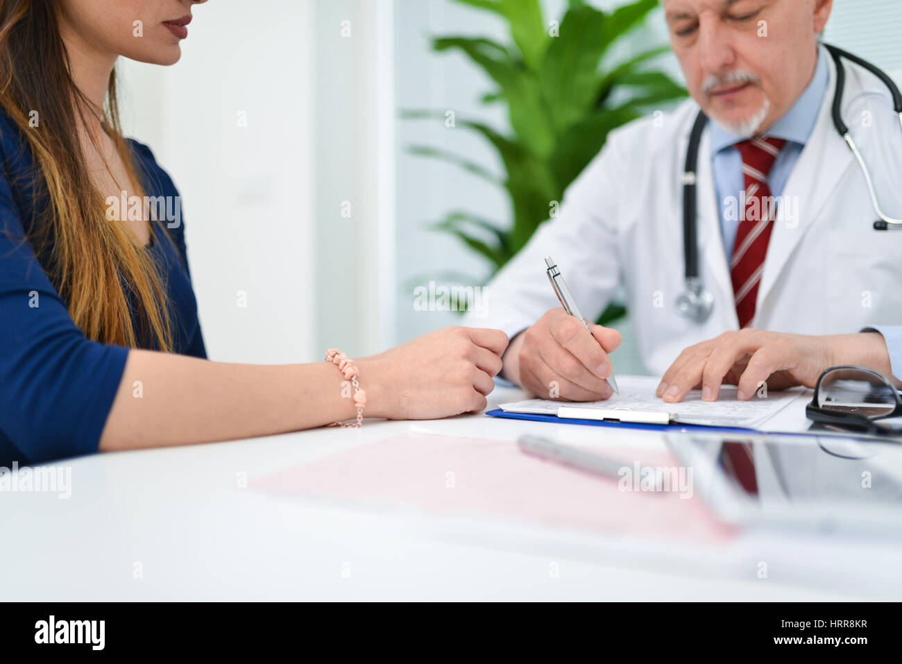 Doctor writing a prescription for a patient Stock Photo - Alamy