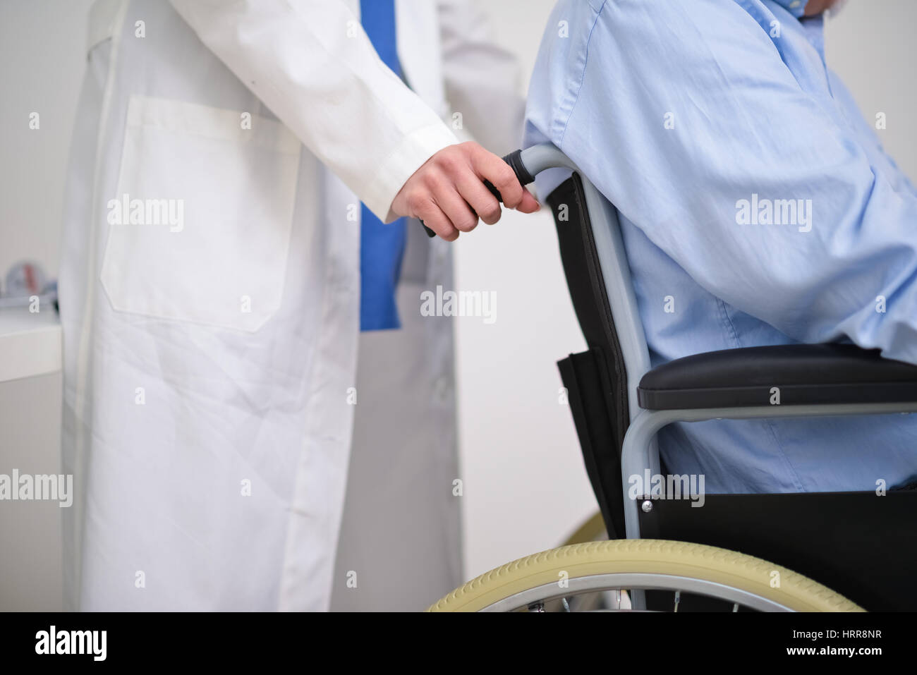 Nurse pushing a patients wheelchair Stock Photo - Alamy