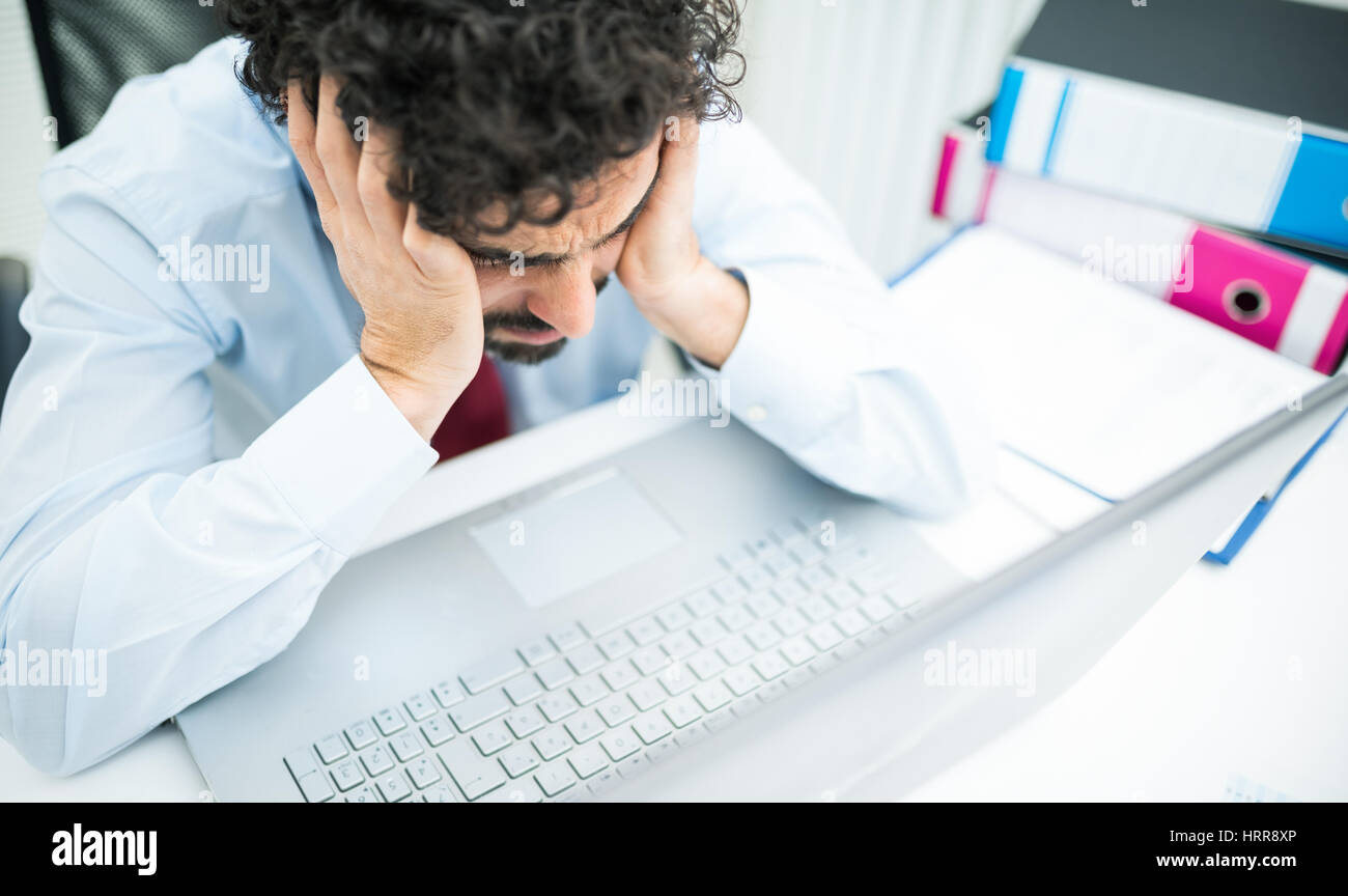Desperate businessman in front of his laptop computer Stock Photo - Alamy