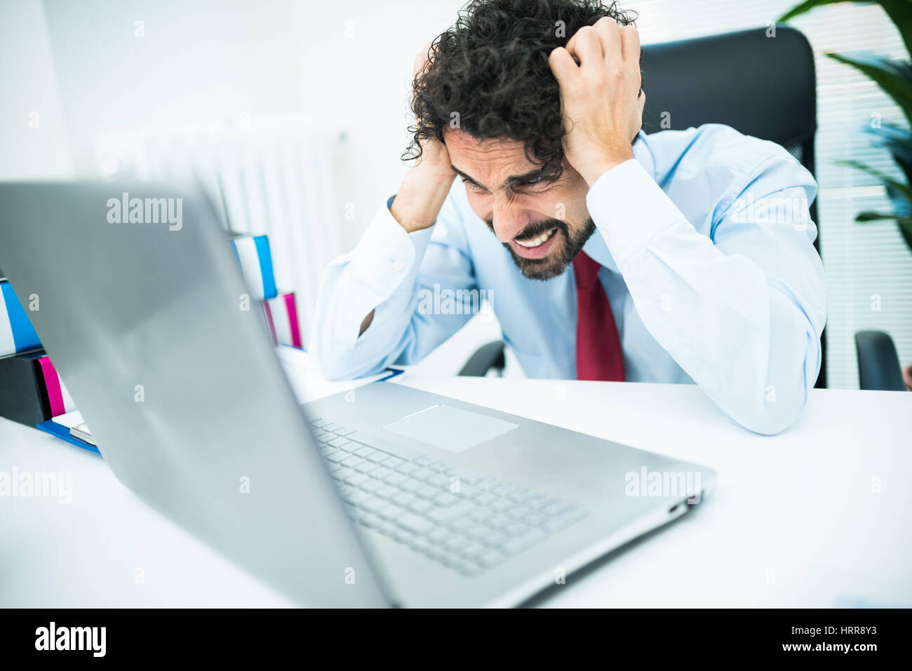 Very angry businessman looking at a computer screen in his office Stock ...