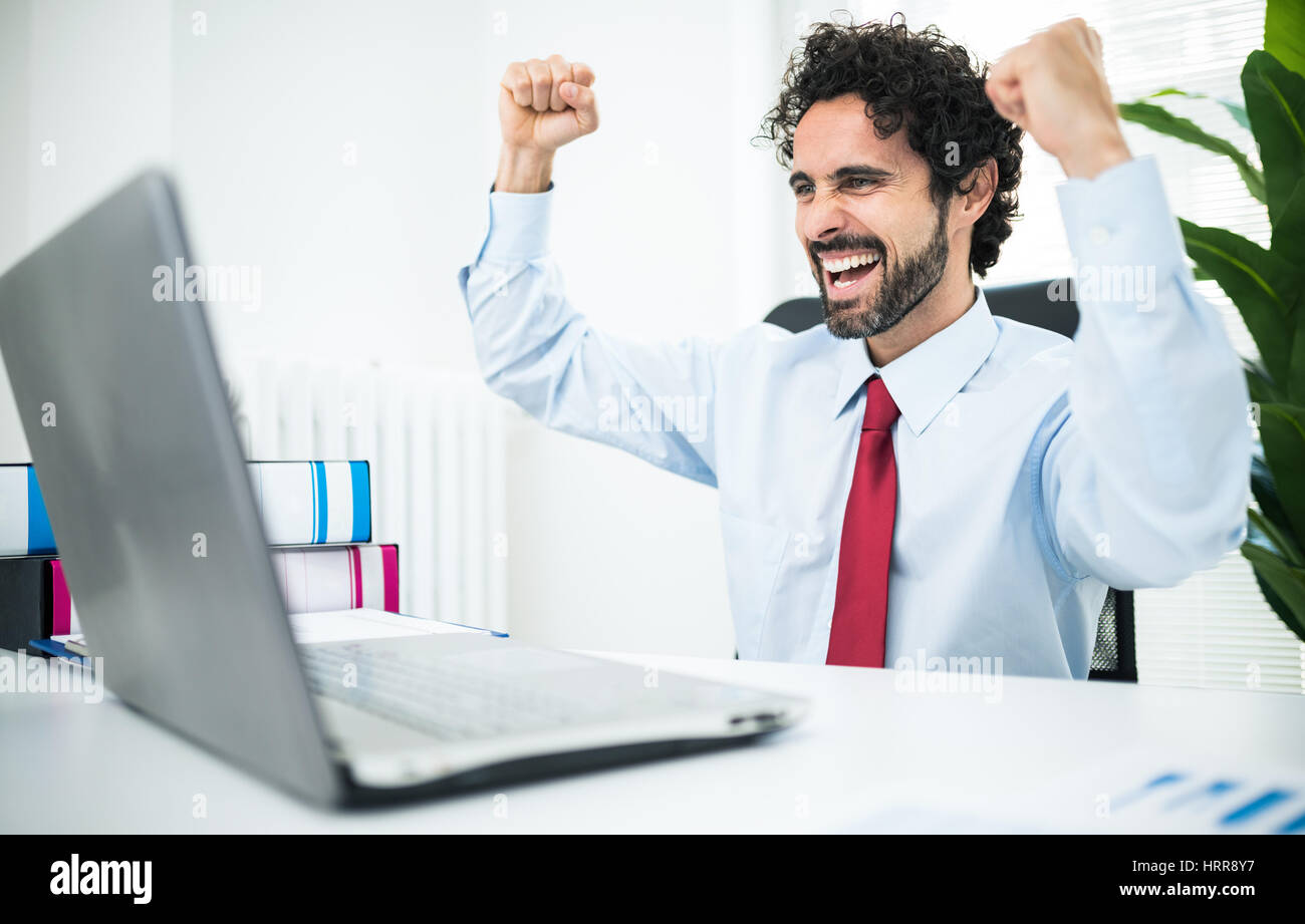 Very happy and excited businessman looking at his computer Stock Photo ...