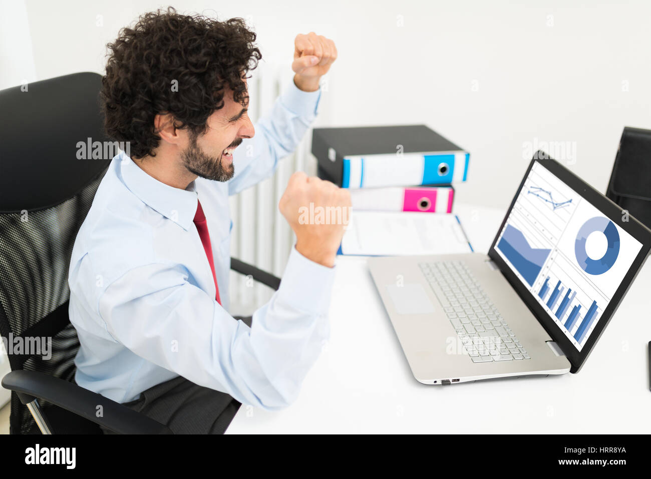 Very happy businessman looking at his computer monitor Stock Photo - Alamy