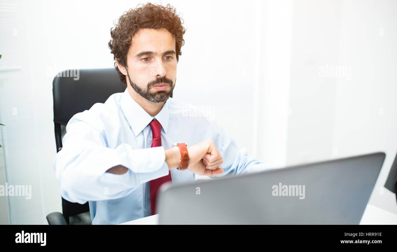 Bored businessman looking at his wrist watch Stock Photo - Alamy