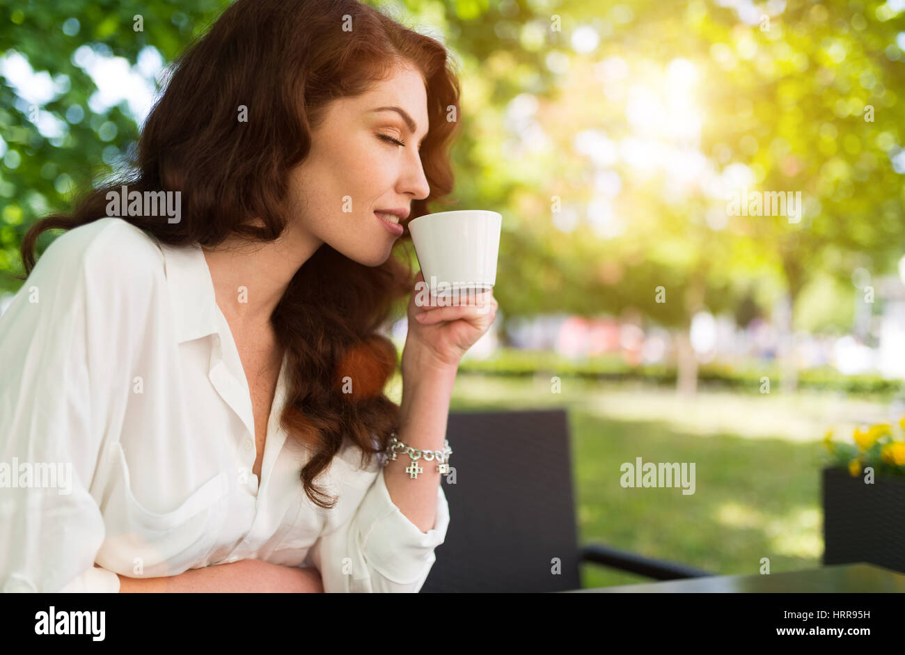 Woman smelling and drinking tea outdoor Stock Photo - Alamy