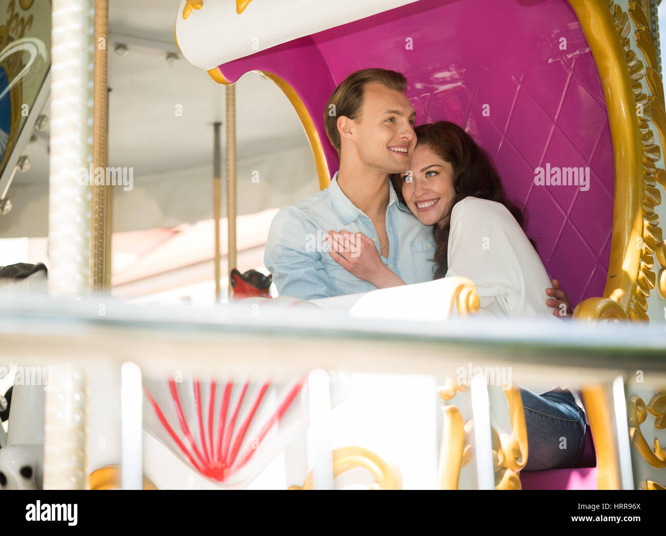 Joyful couple having fun on a carousel Stock Photo - Alamy