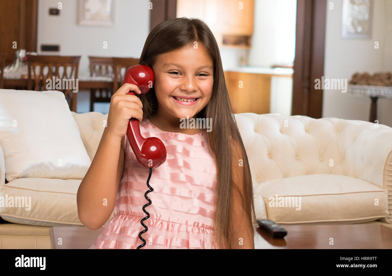 Smiling little girl talking on a vintage telephone at home Stock Photo ...