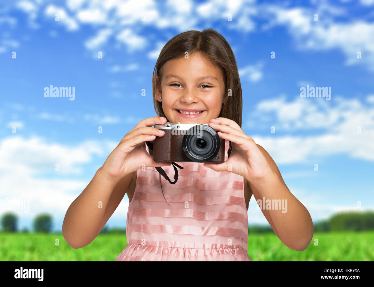 Smiling child holding a compact camera outdoors Stock Photo - Alamy
