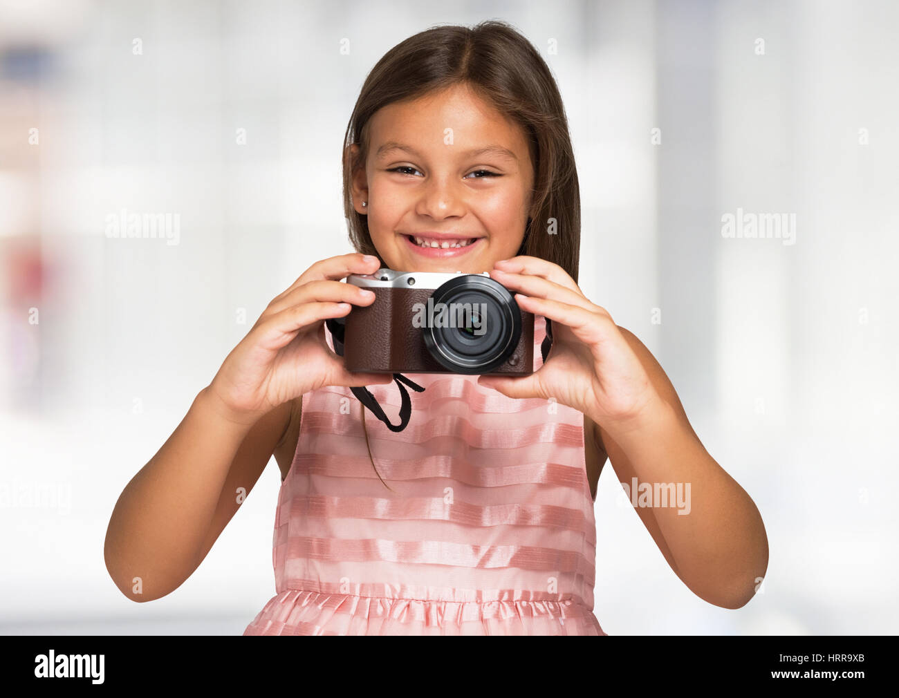 Smiling child holding a compact camera. Bright blurred background Stock ...