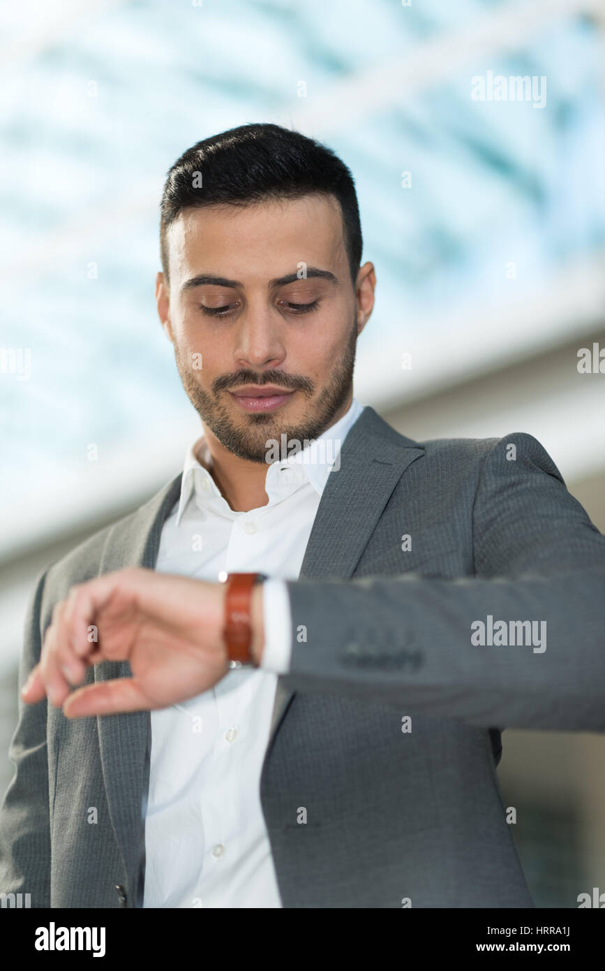 Businessman looking at his watch Stock Photo - Alamy