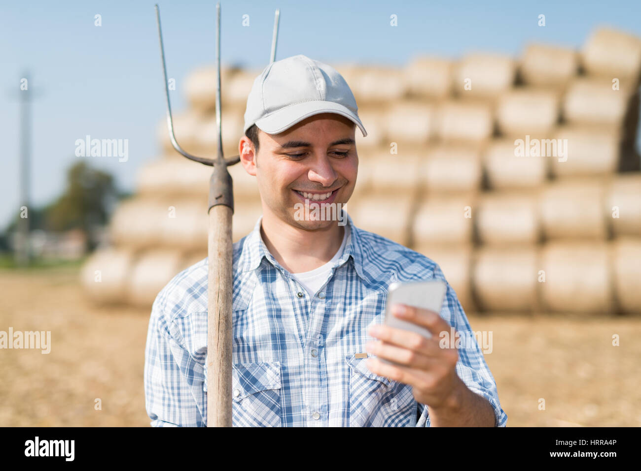 Modern farmer using his mobile phone Stock Photo - Alamy