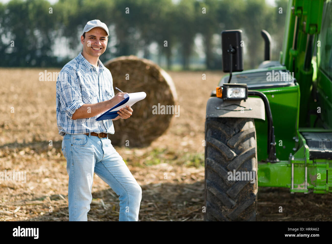 Smiling farmer writing on a document Stock Photo - Alamy