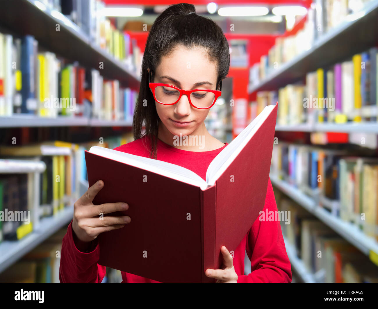 Teenager reading a book in a library Stock Photo - Alamy