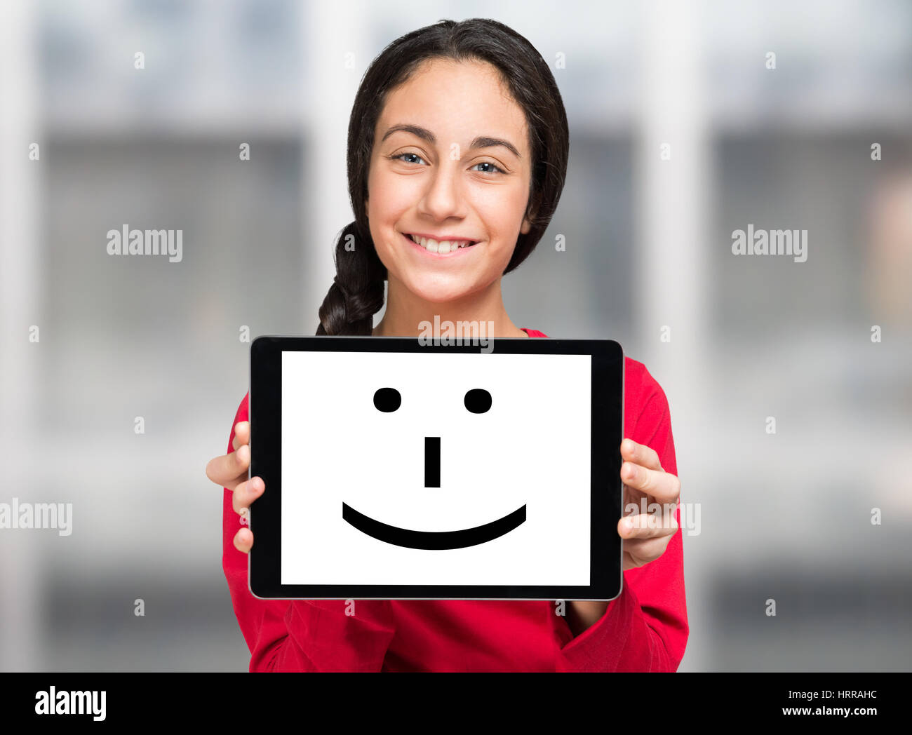 Young girl holding a smiling tablet, positivity concept Stock Photo - Alamy
