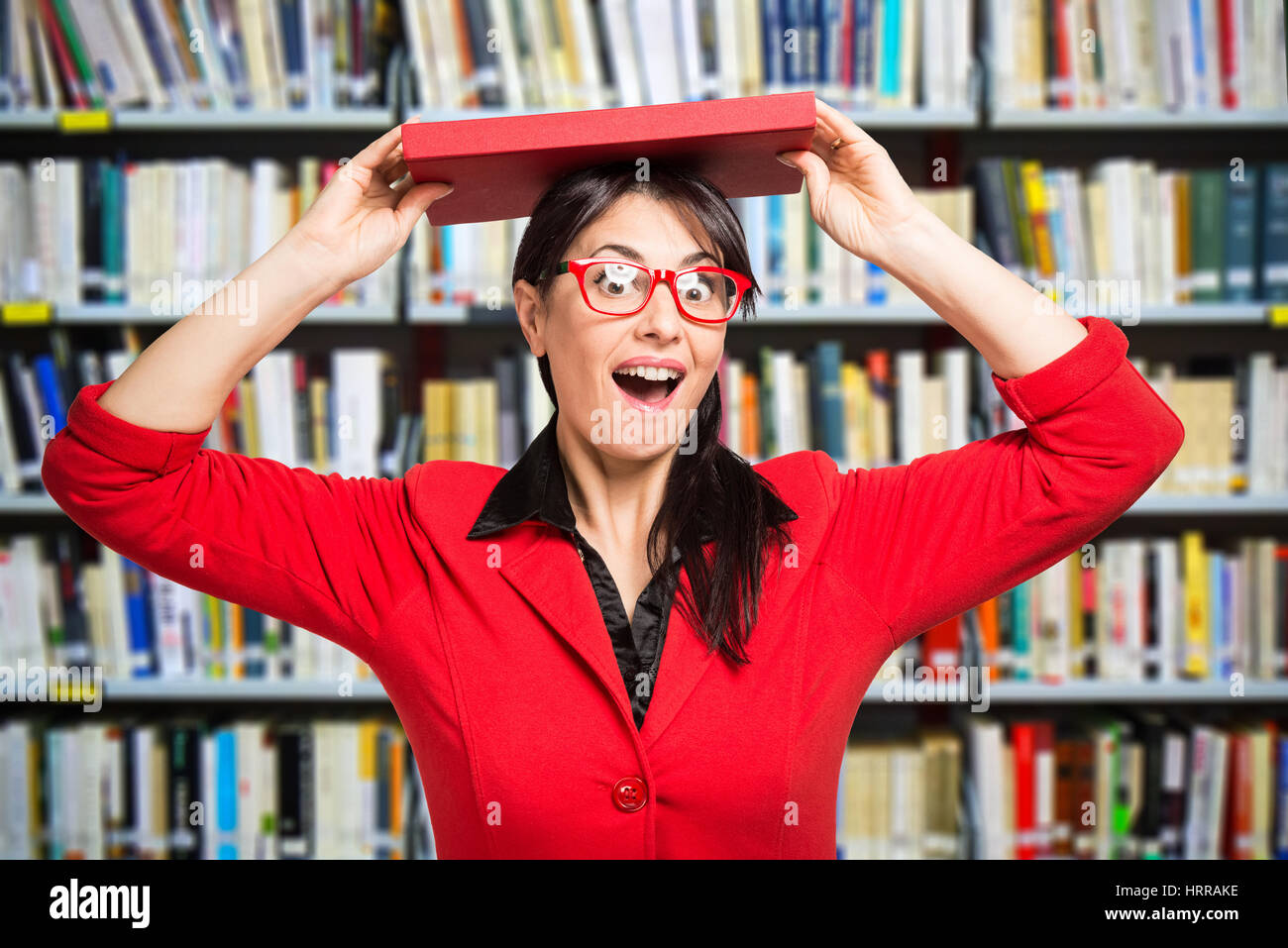 Smiling red dressed woman in a library Stock Photo - Alamy