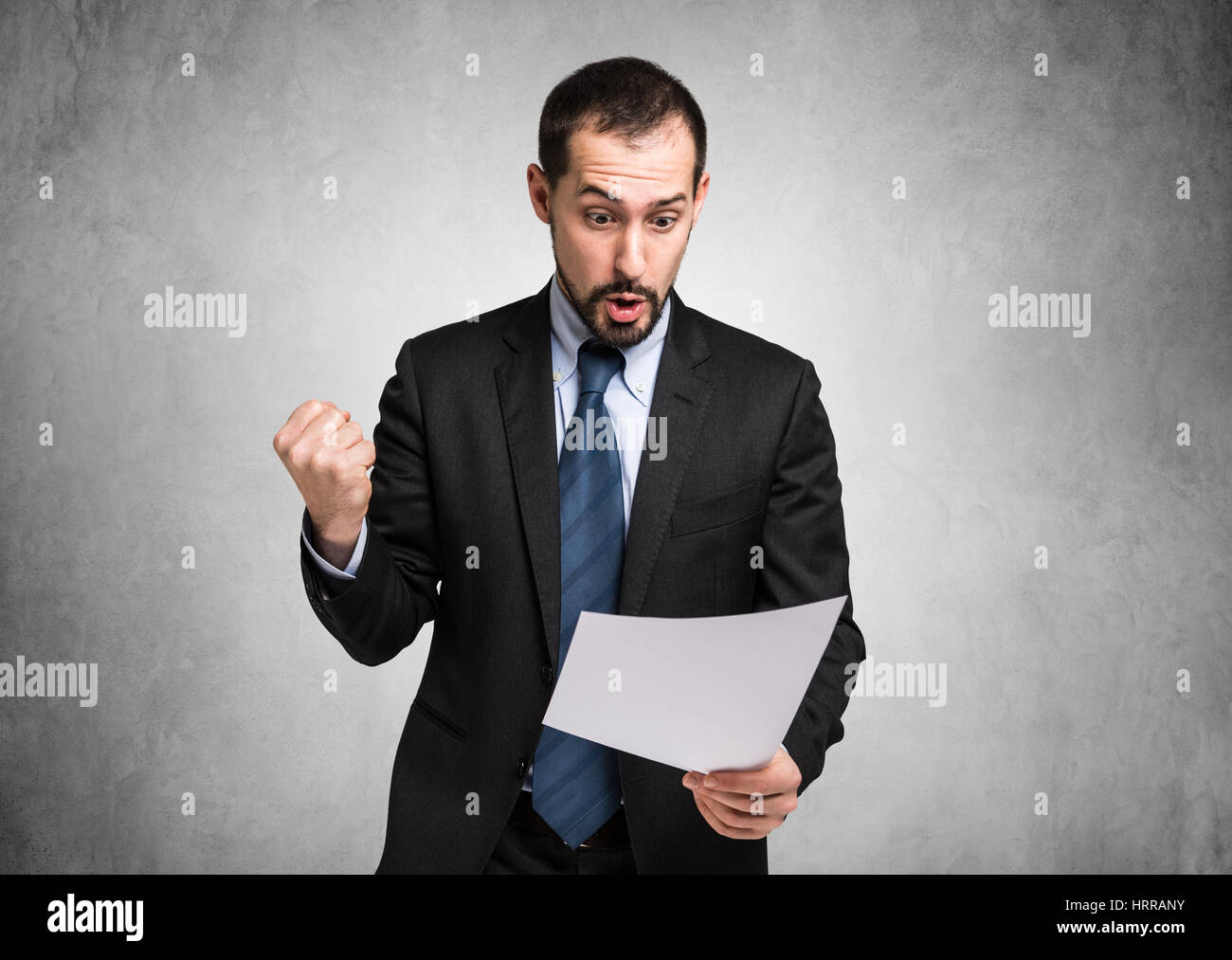 Very happy businessman reading a document Stock Photo - Alamy