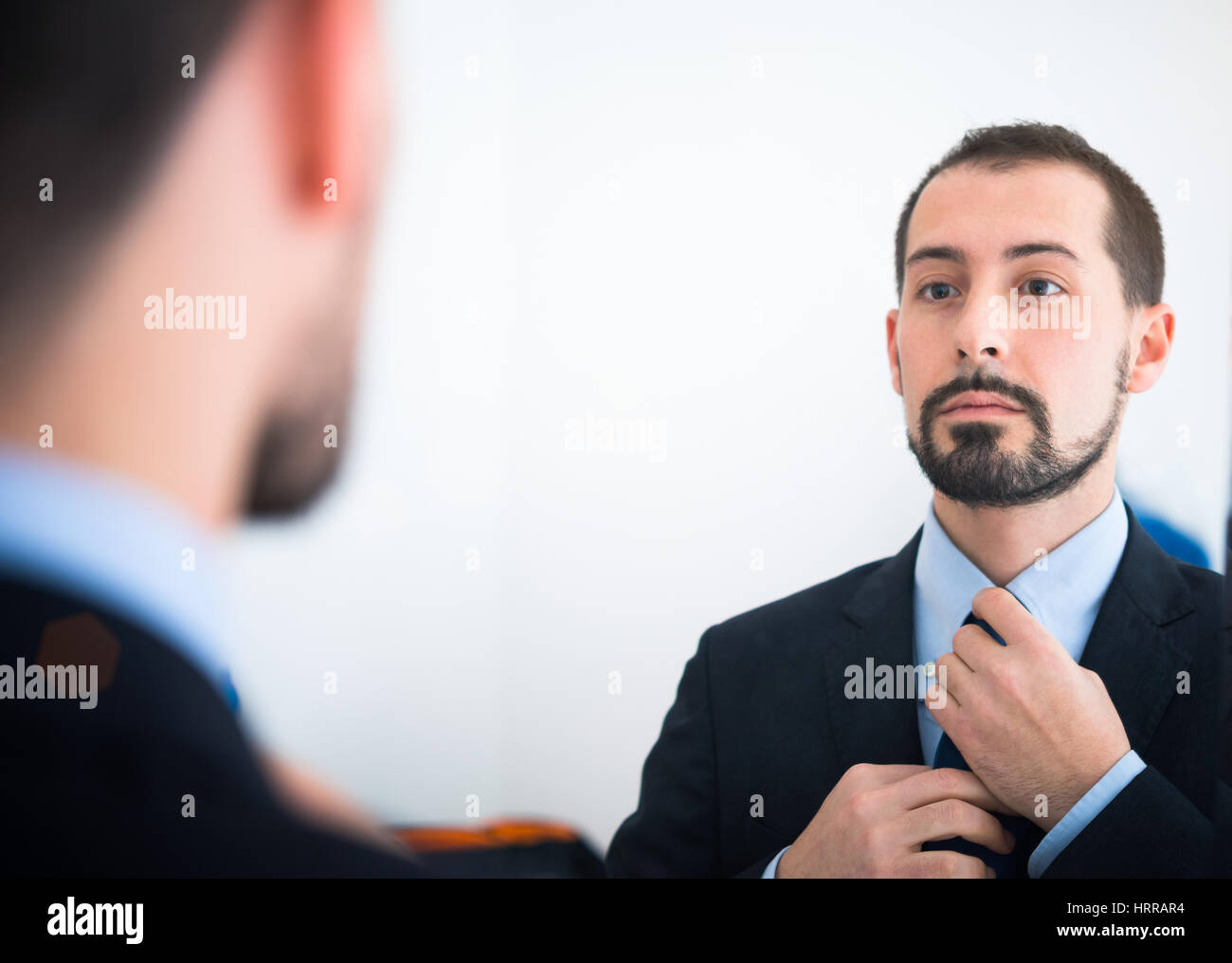 Portrait of a businessman looking at himself in the mirror Stock Photo ...