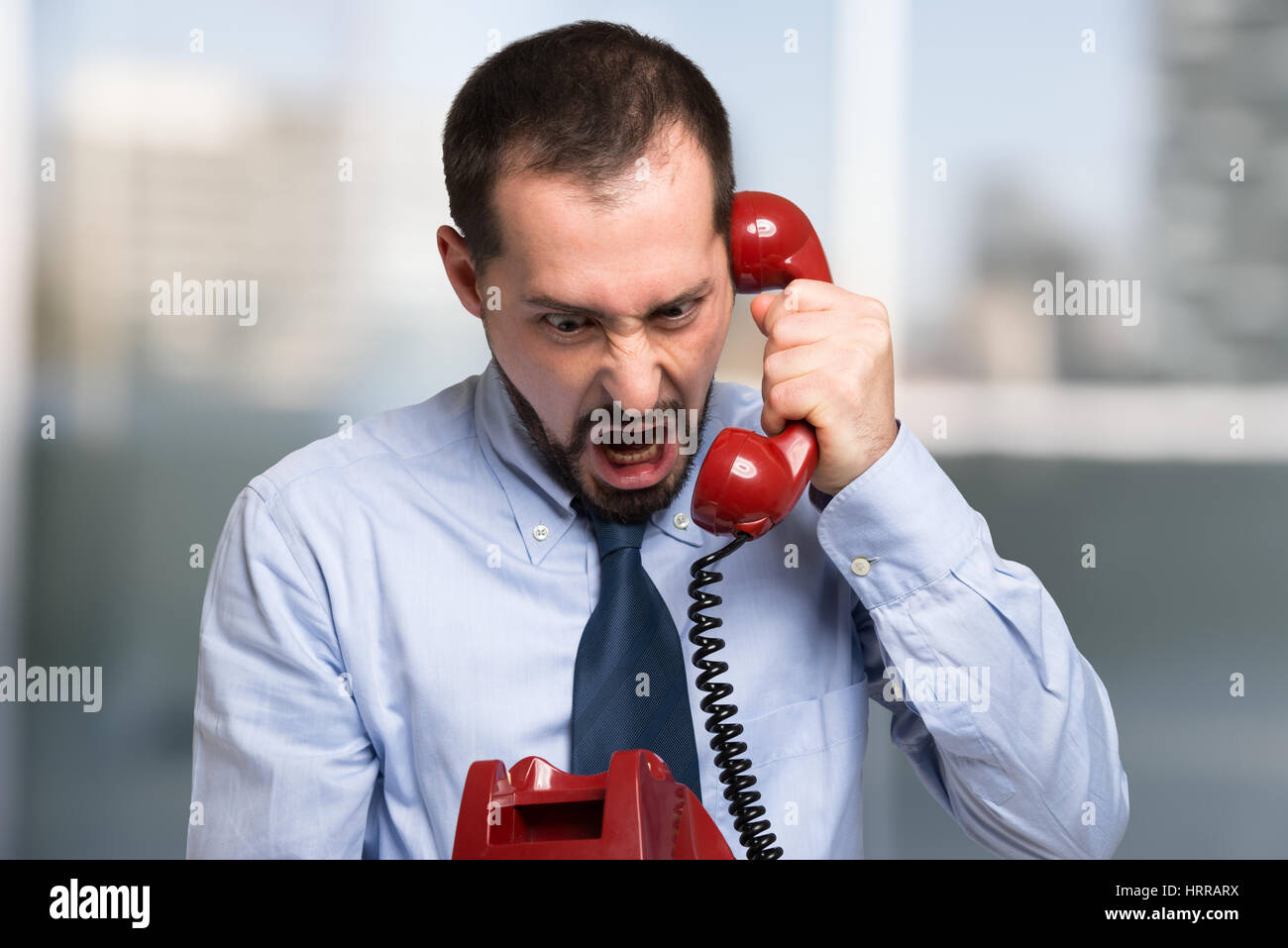 Angry businessman yelling on the phone Stock Photo - Alamy