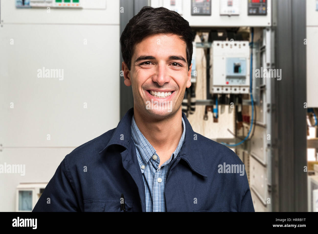 Smiling electrician in front of an electrical panel Stock Photo - Alamy