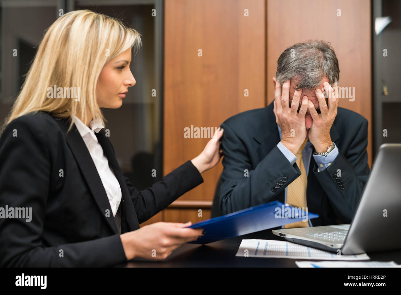 Secretary comforting her depressed and sad boss Stock Photo - Alamy