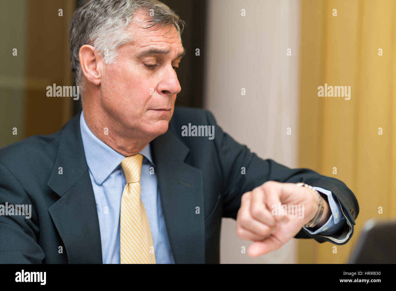 Businessman taking a look at his watch Stock Photo - Alamy