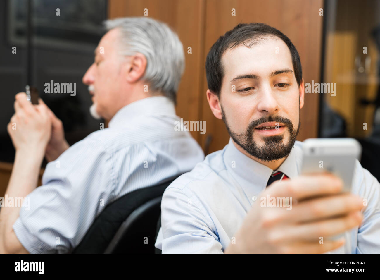 Business people using their mobile phone in the office Stock Photo - Alamy