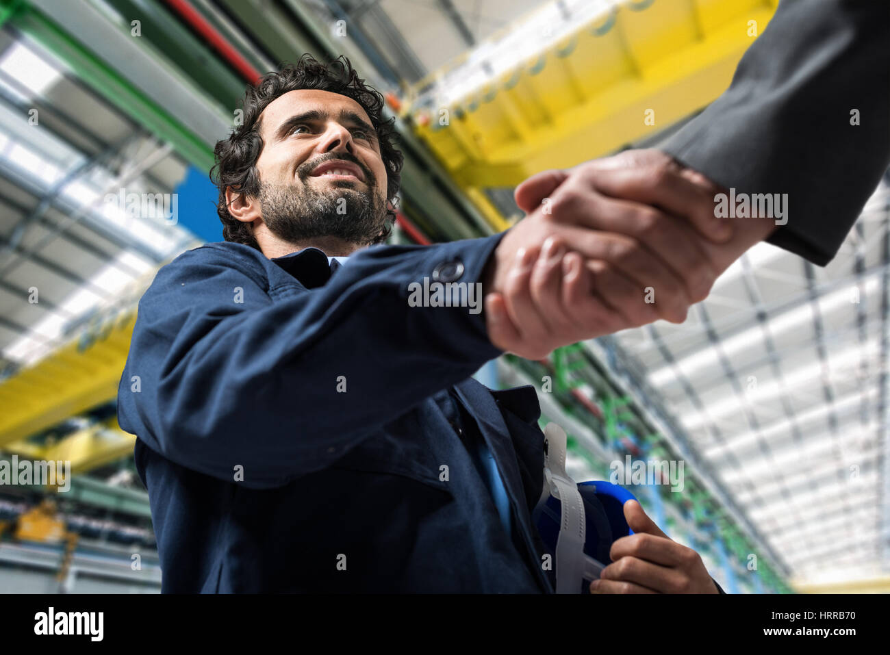 Portrait of a man giving an handshake in an industrial facility Stock ...