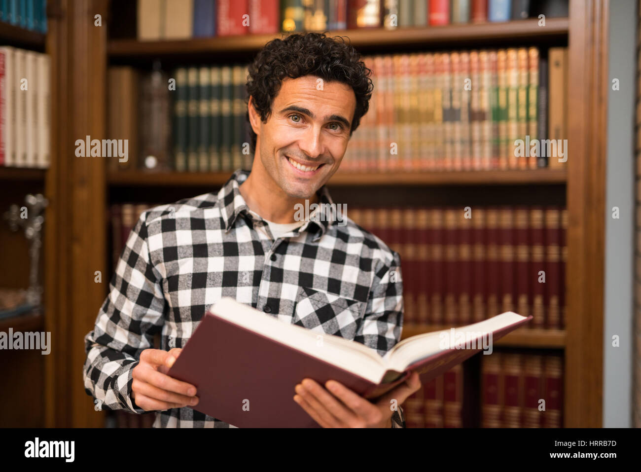 Smiling man reading a book Stock Photo - Alamy