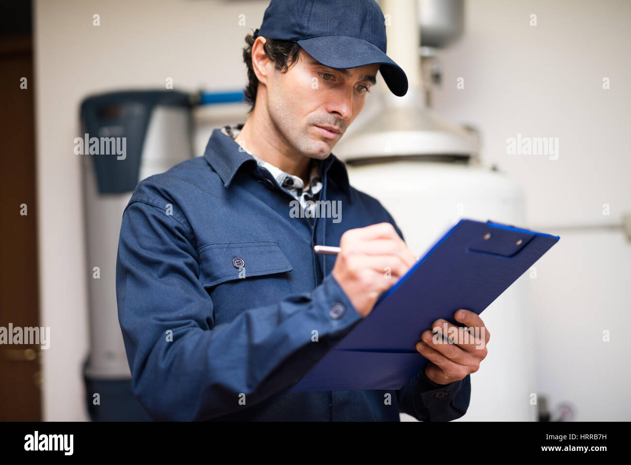 Plumber writing on a clipboard Stock Photo - Alamy