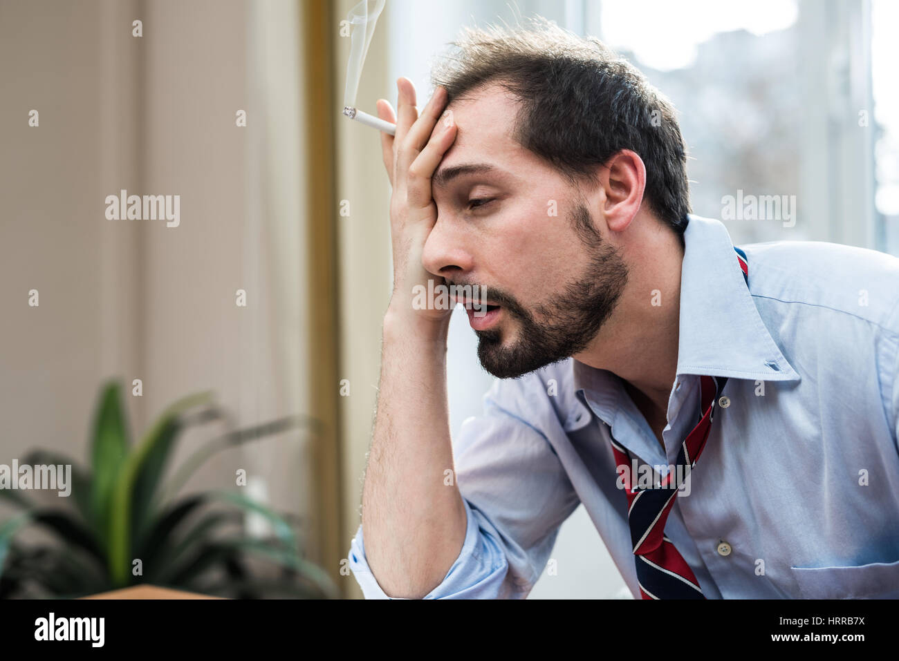 Portrait of a shocked businessman smoking a cigarette Stock Photo - Alamy