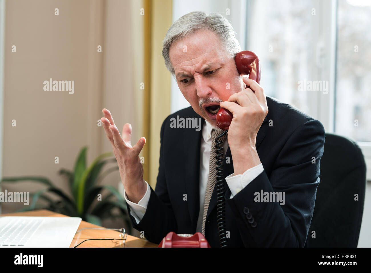 Angry businessman yelling on the phone Stock Photo - Alamy