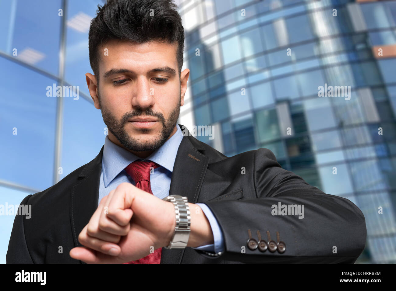 Handsome businessman looking at his watch Stock Photo - Alamy