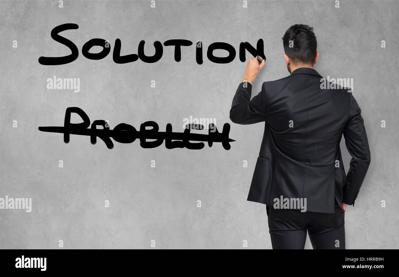 Businessman writing the word Solution on the wall Stock Photo - Alamy