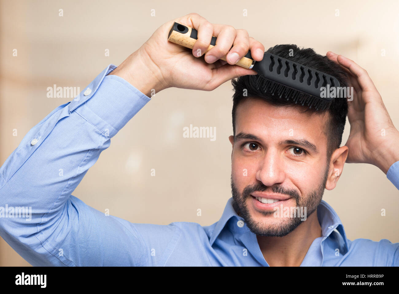 Portrait of a man combing his hair Stock Photo - Alamy