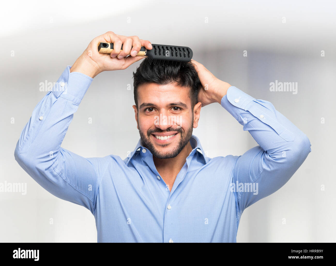 Happy man combing his hair Stock Photo - Alamy