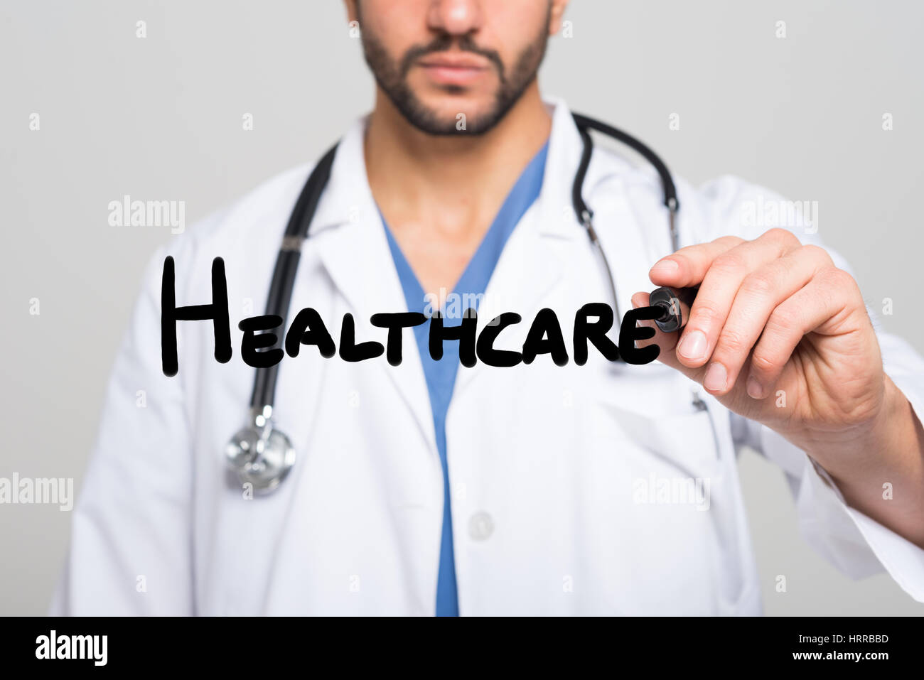 Doctor writing the word Healthcare Stock Photo - Alamy