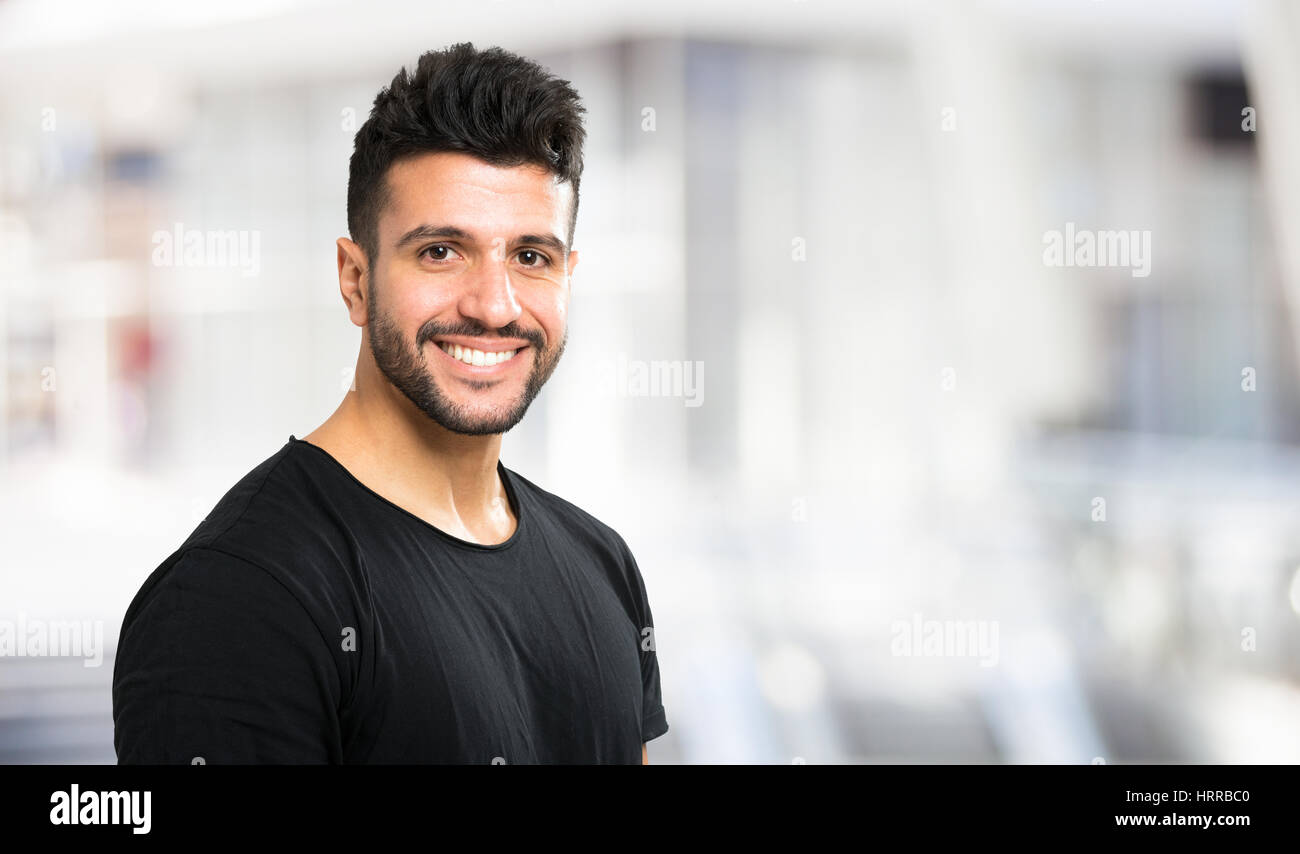 Young smiling man. Bright blurred background Stock Photo - Alamy