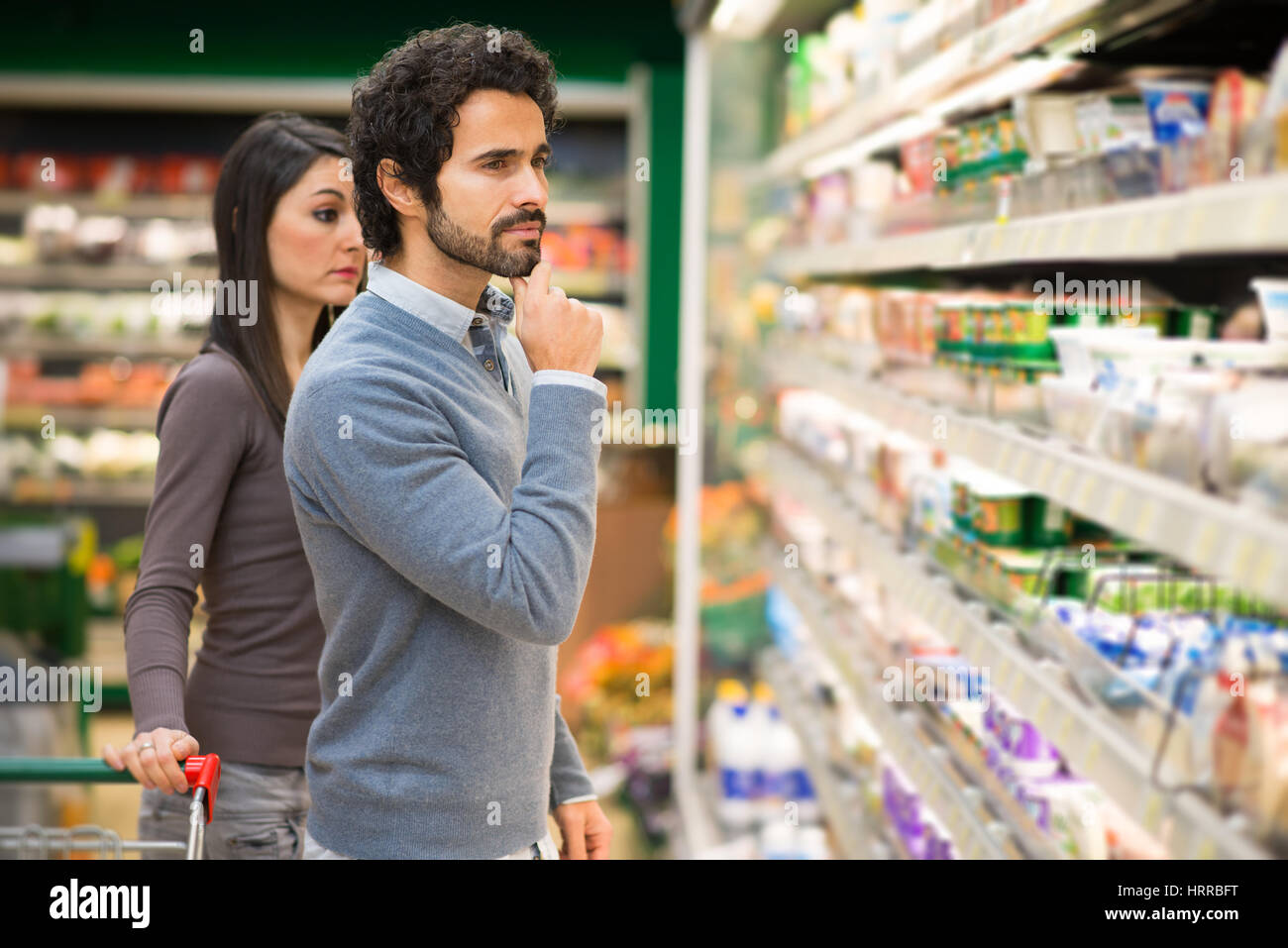 Young couple choosing the best food in a supermarket Stock Photo - Alamy