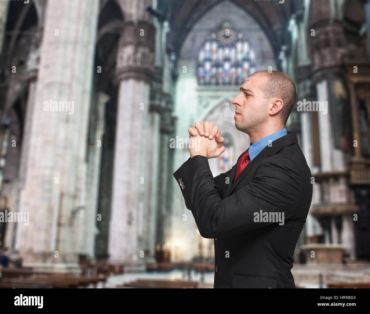 Penitent businessman praying in a church Stock Photo - Alamy