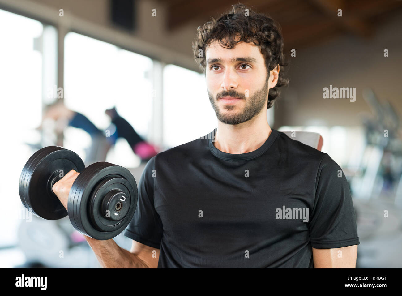 Bodybuilder using a dumbbell to work out Stock Photo - Alamy