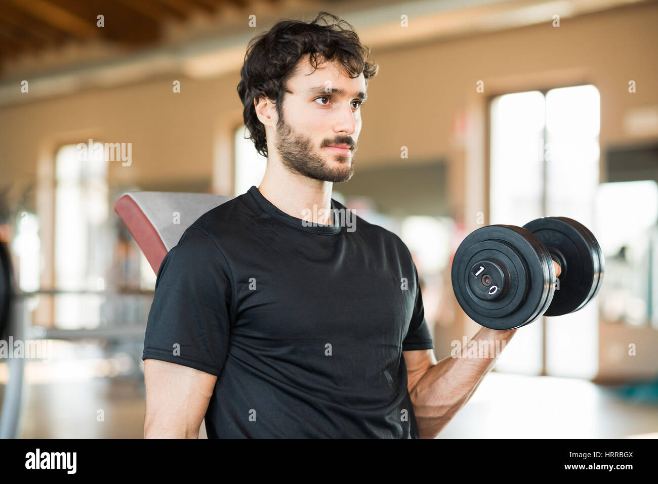 Bodybuilder using a dumbbell to work out Stock Photo - Alamy