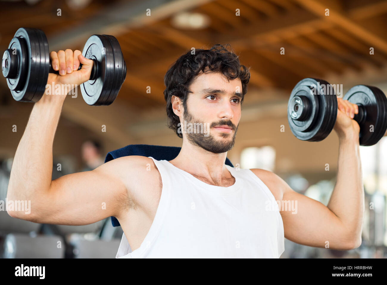 Man lifting weights in a gym Stock Photo - Alamy