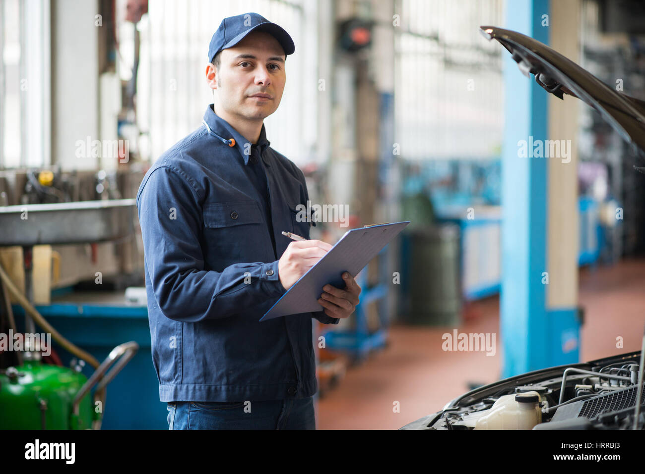 Mechanic writing on a clipboard Stock Photo - Alamy